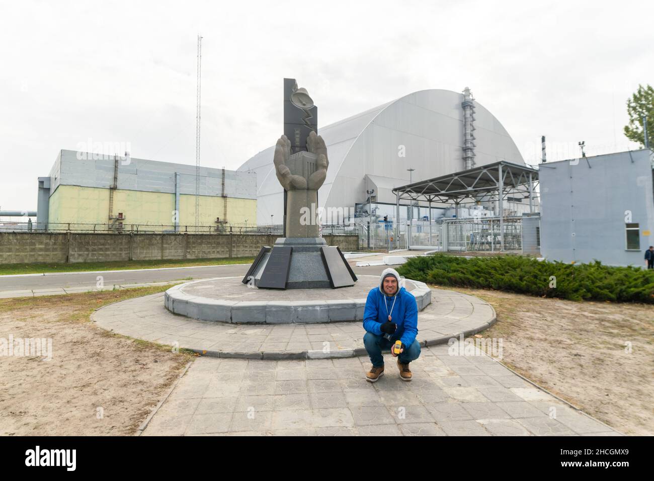 Male tourist person stands by Chernobyl memorial and power reactor ...