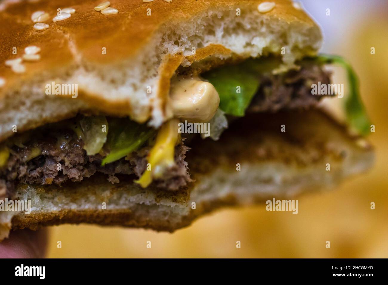 Close up detail of a bitten cheeseburger. Food, junk food and fast food ...