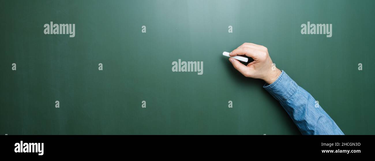 Hand of teacher holding chalk in front of blank blackboard Stock Photo ...