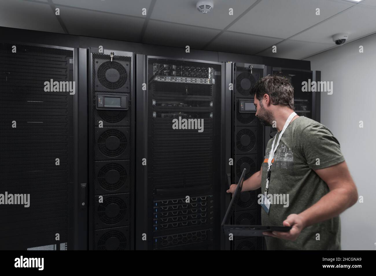 Data Center Engineer Usaing Keyboard on a Supercomputer Server Room ...