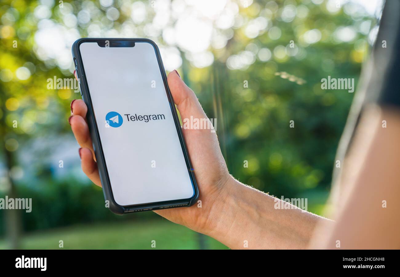 Woman hand holding iphone Xs with logo of Telegram application ...