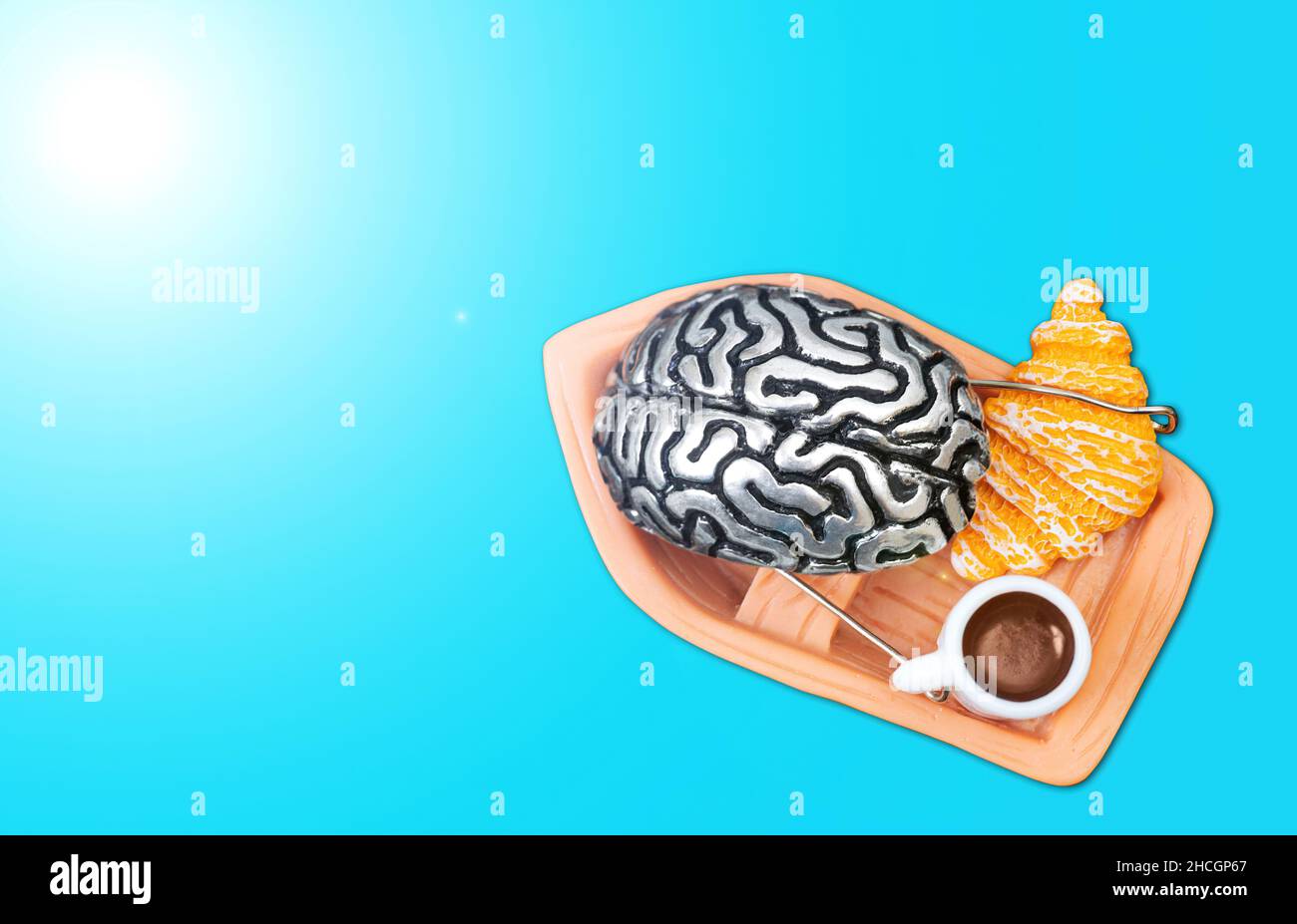 Miniature copy of a human brain in a toy wooden boat holding a cup of ...