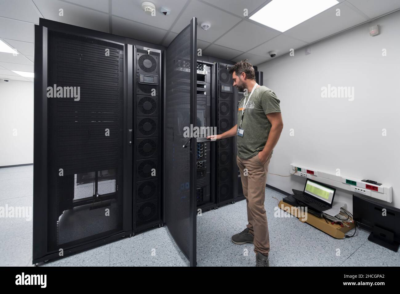 Data Center Engineer Usaing Keyboard on a Supercomputer Server Room ...