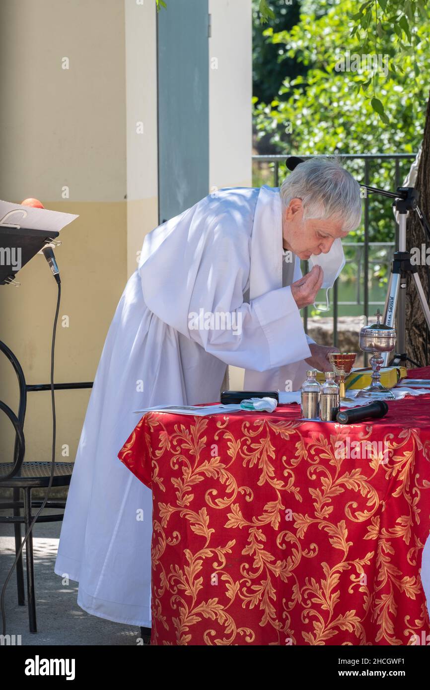 Catholic priest wearing white habit is celebrating the holy mass in ...