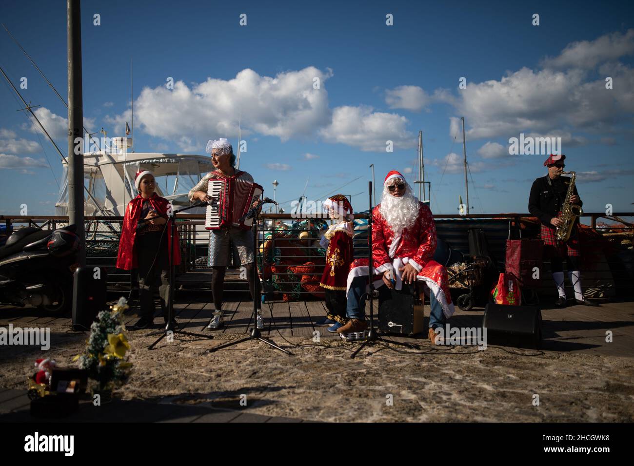 A band dressed in Santa Claus costumes play at the Jaffa port in Tel ...