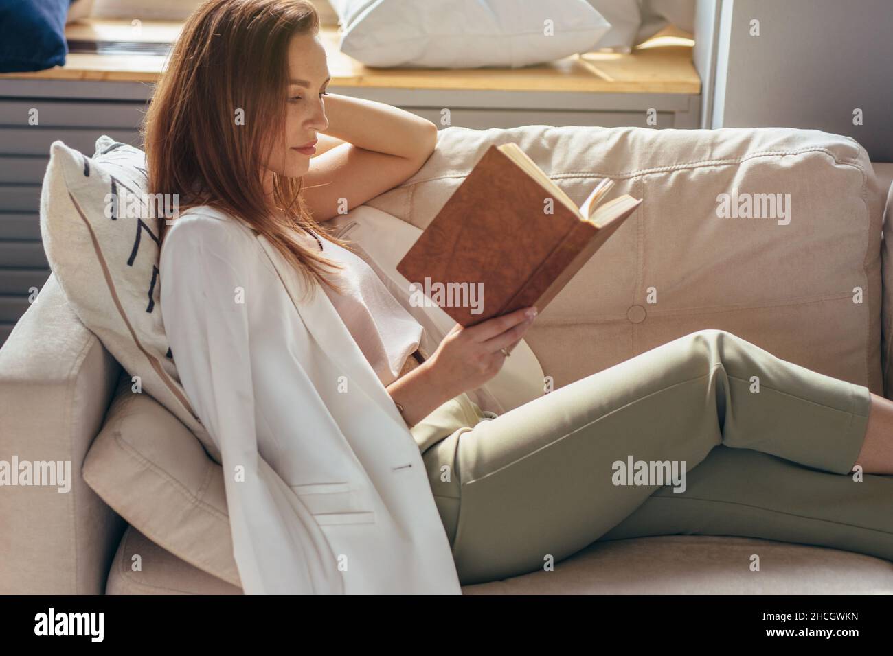 Woman resting at home and reading book Stock Photo - Alamy