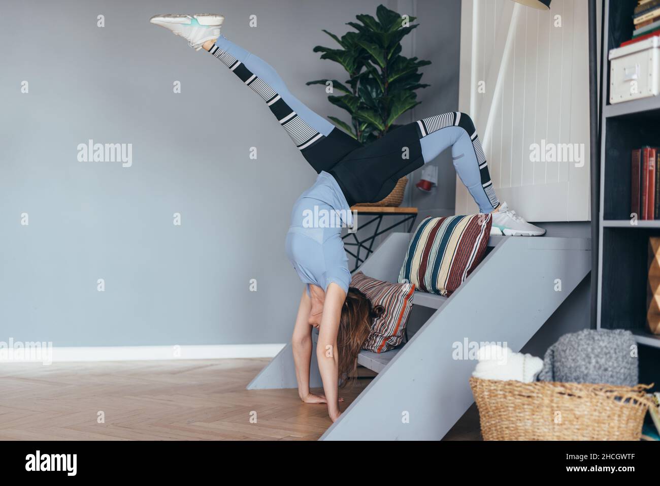 Fitness woman doing backbend stretching exercise at home, working out ...