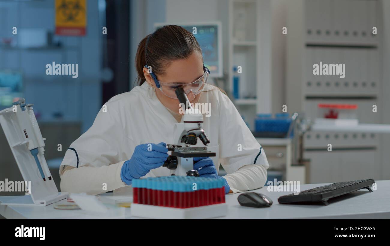 Microbiologist working with microscopic tool to research substance in ...