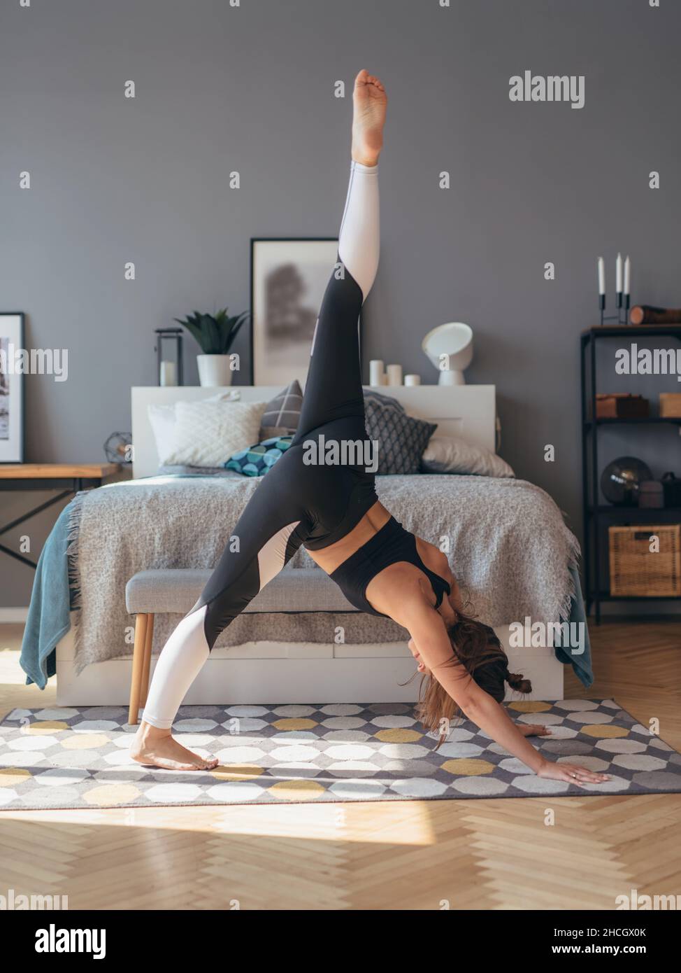 Fitness woman practising yoga at home she doing forward bend stretching ...