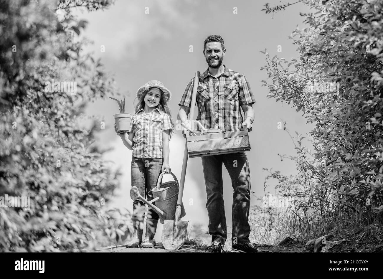 Green life. farmer man with little girl. garden tools, shovel and ...