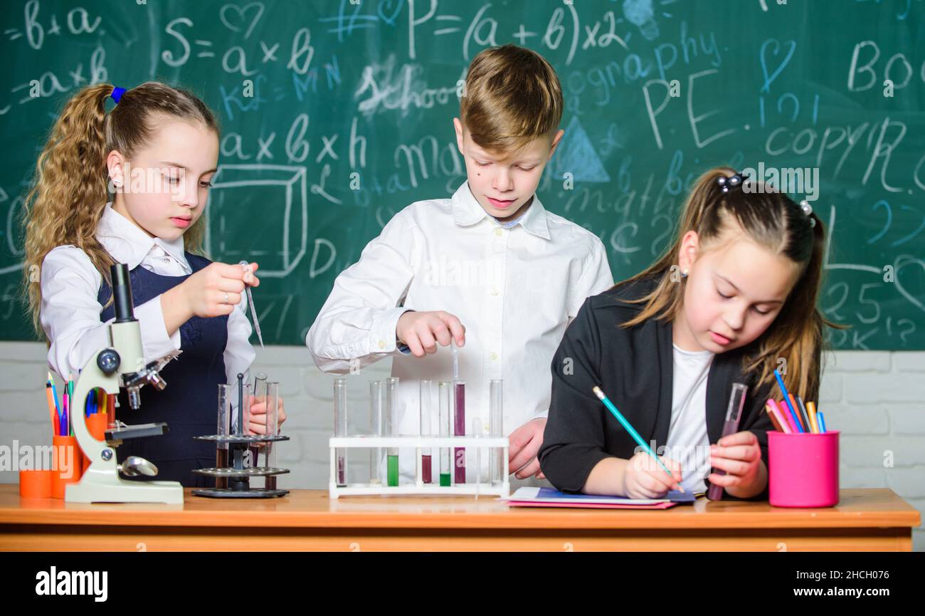 students doing biology experiments with microscope. Little children at ...