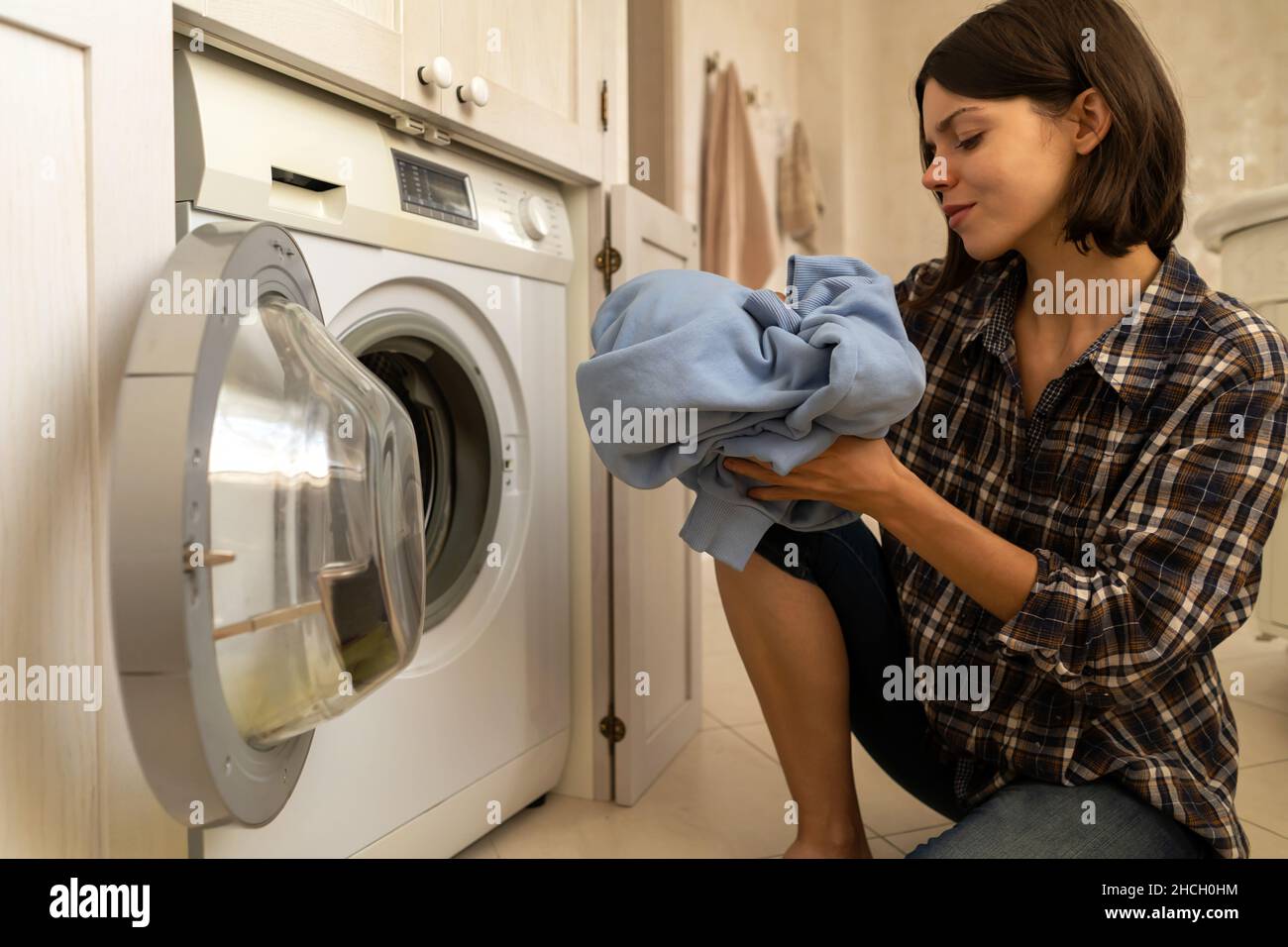 Girl puts clothes in washing mashine Stock Photo - Alamy
