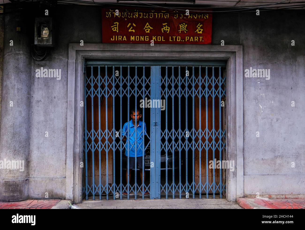 A man stares out of a shuttered building in the Talat Noi area of ...