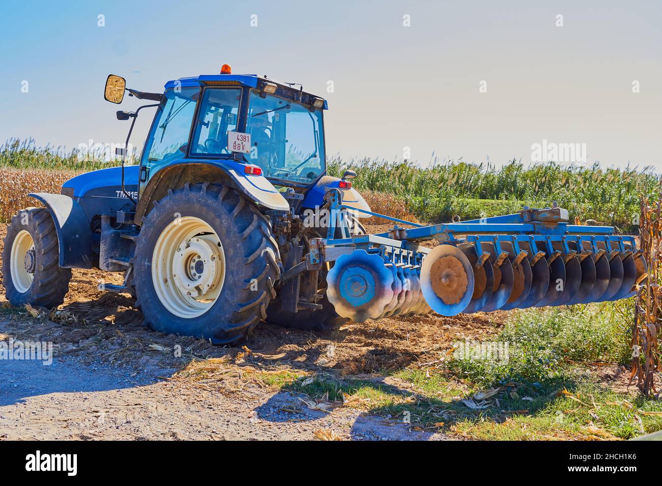 man driving tractor plowing land Stock Photo - Alamy