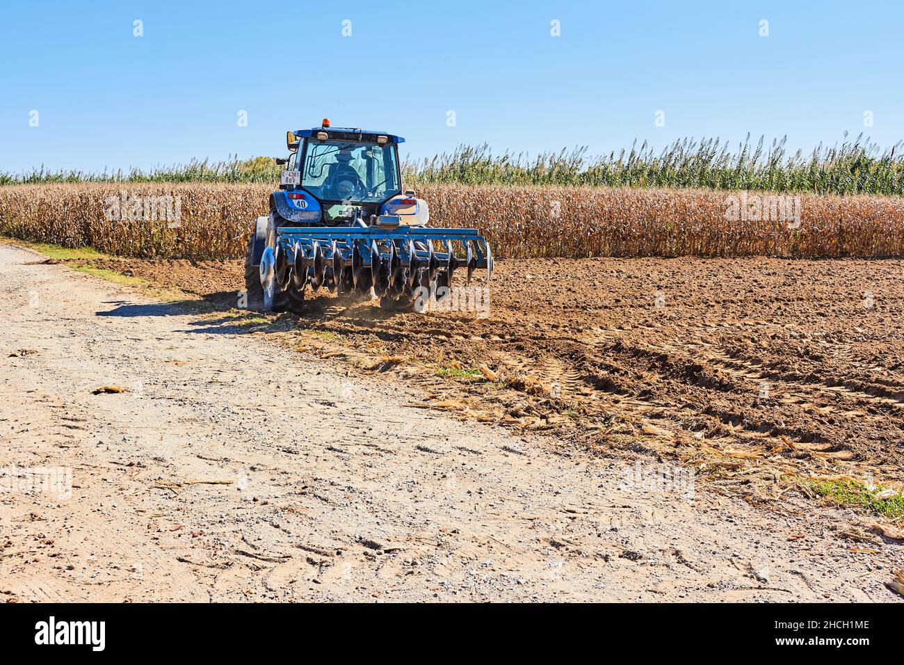 man driving tractor plowing land Stock Photo - Alamy