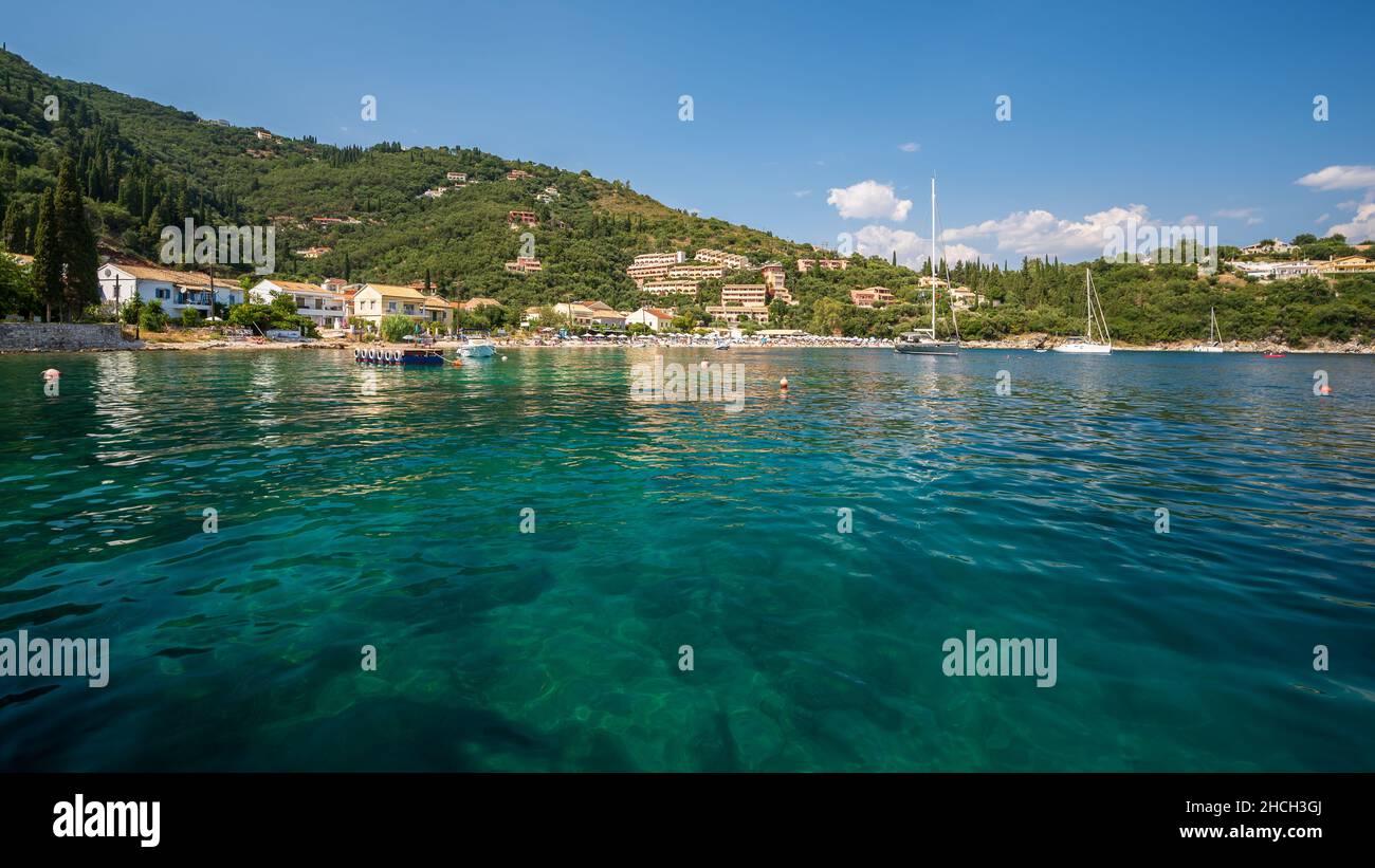 The clear waters of Kalami Bay, in Corfu, Greece, on a bright summers ...