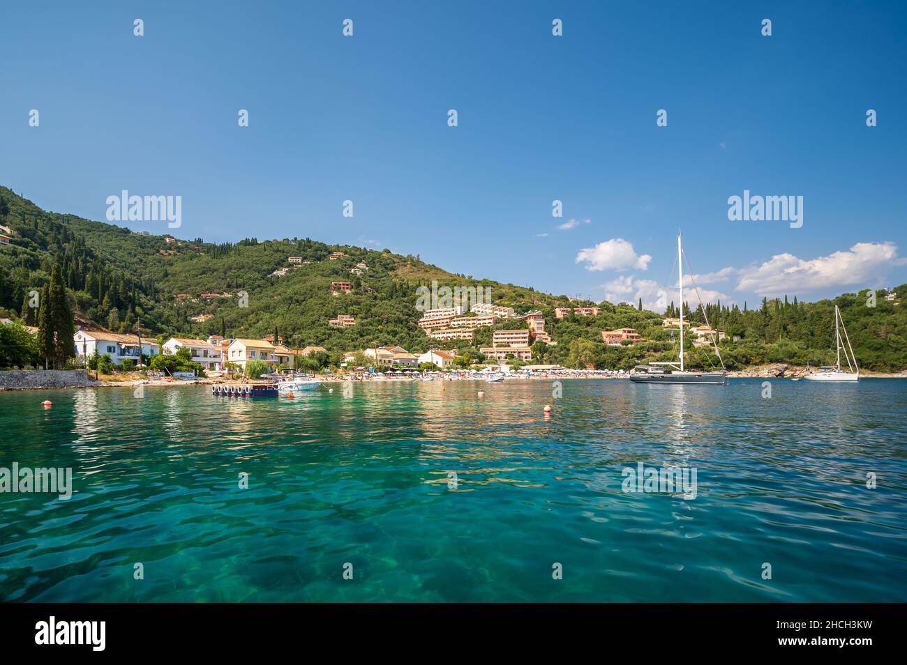 The clear waters of Kalami Bay, in Corfu, Greece, on a bright summers ...