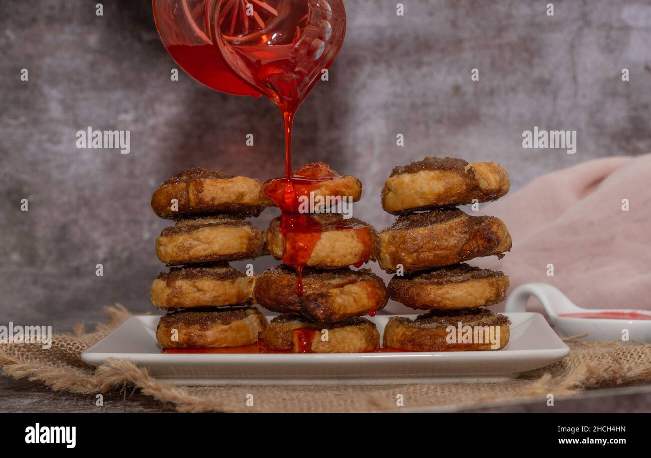 cinnamon and sugar rolls covered with strawberry syrup added with a ...