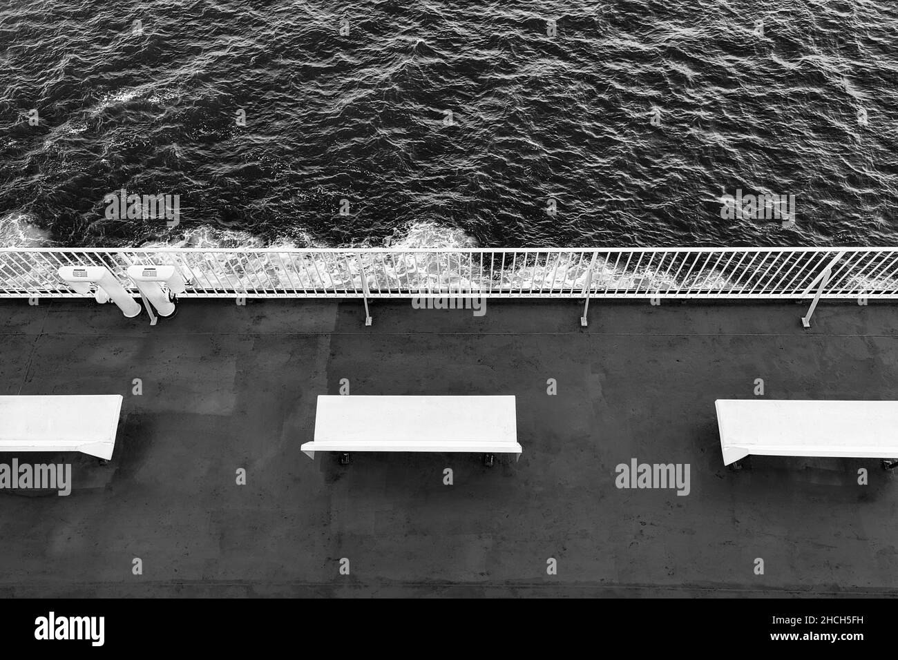 Three benches from above, side by side, railing, outside deck of a ...
