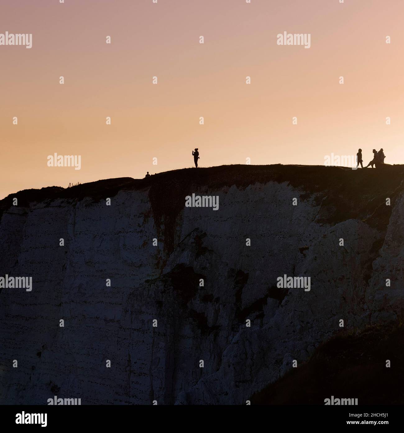 Walkers, silhouettes on cliff, sunset, Beachy Head, Eastbourne, Sussex ...