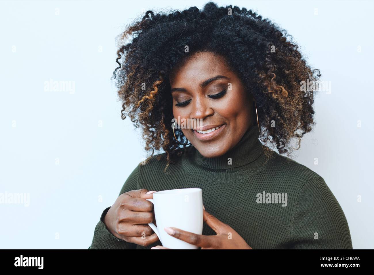 Adult African American woman thinking and drinking coffee Stock Photo ...