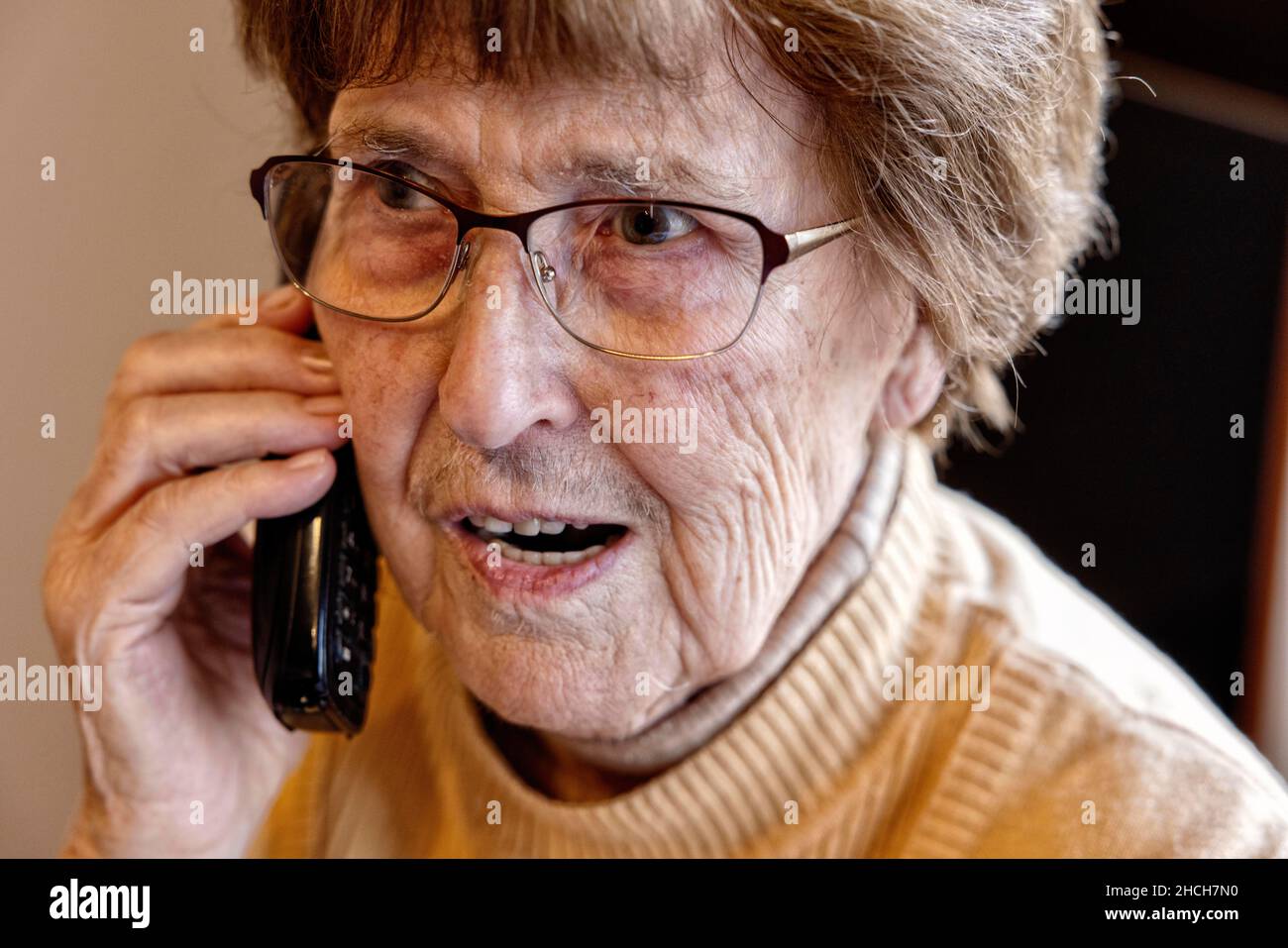 Senior woman at home talking on a phone, Cologne, North Rhine ...