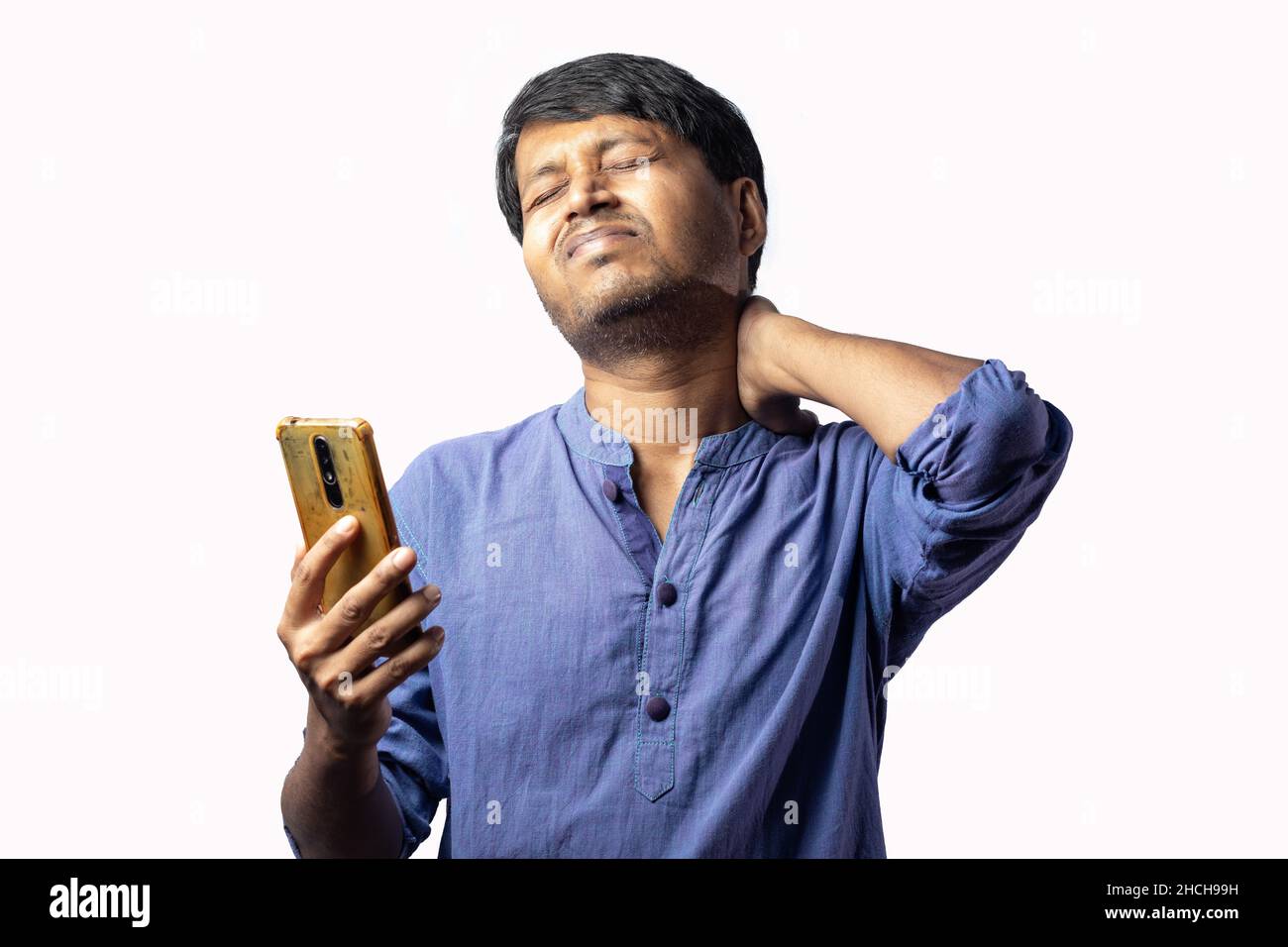 A young Indian male in blue dress facing neck pain problem using smart ...