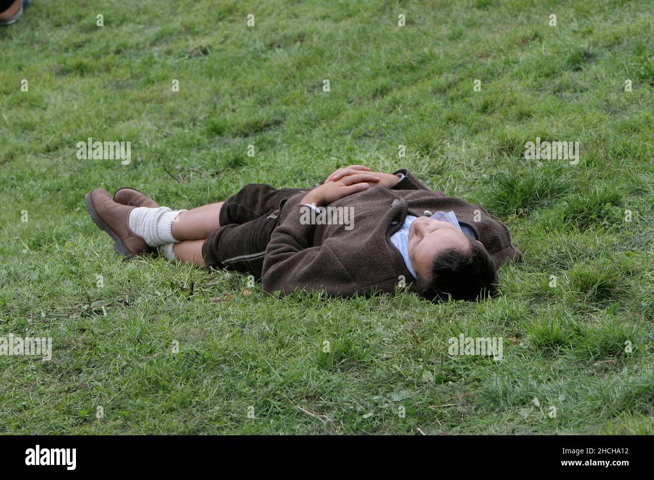 Young man in Bavarian traditional costume sleeps off intoxication from ...