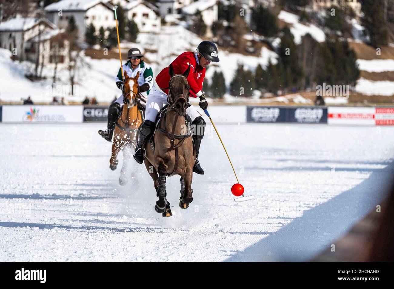 Max Charlton of Team St. Moritz hits the red ball in a flying gallop ...