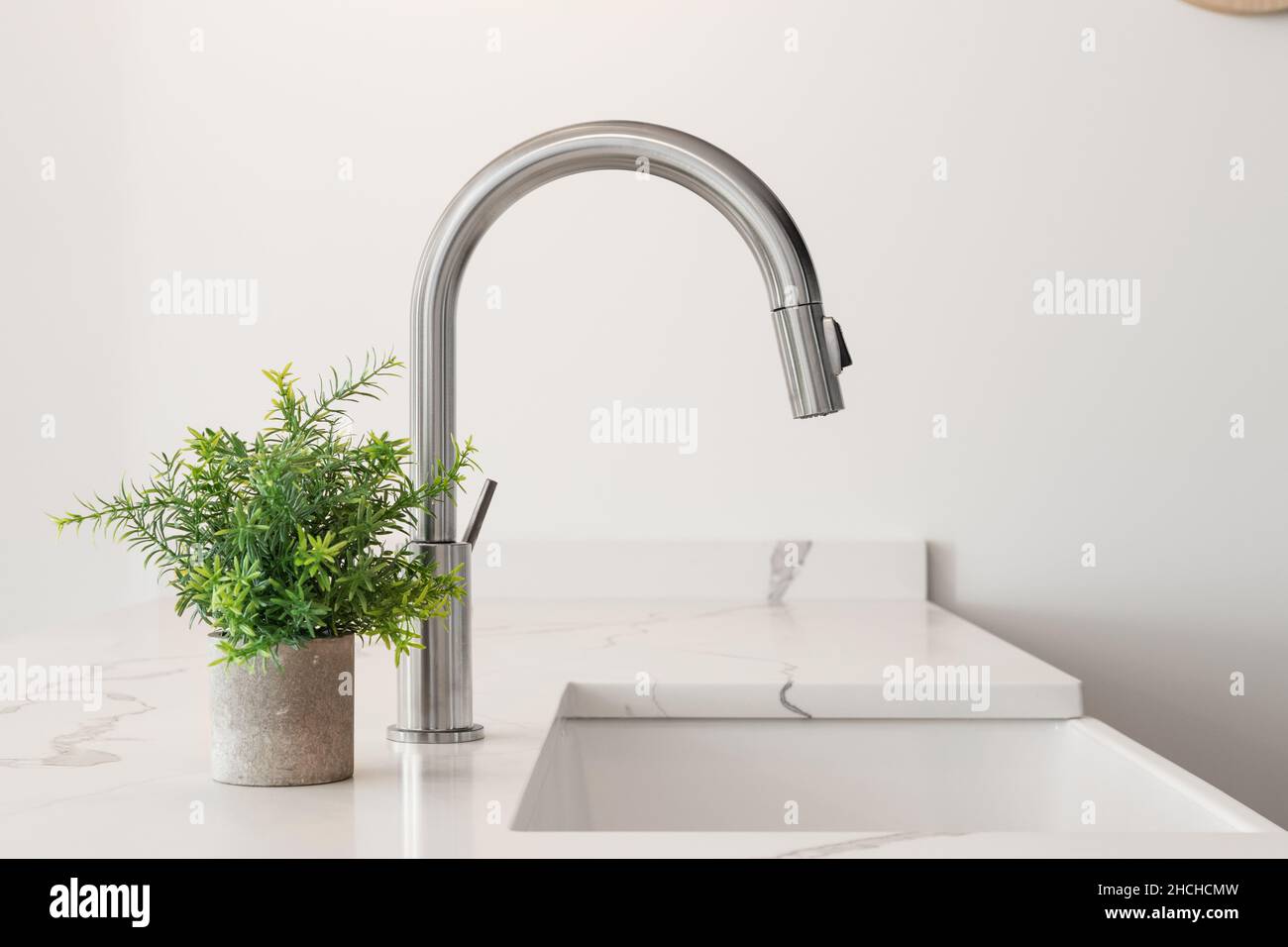 A kitchen sink detail shot with a farmhouse sink, stainless steel ...