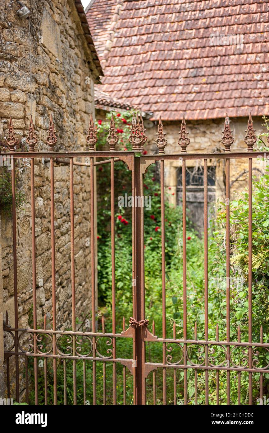 Old rusty metal gate with an old stone builing in the beackground Stock ...