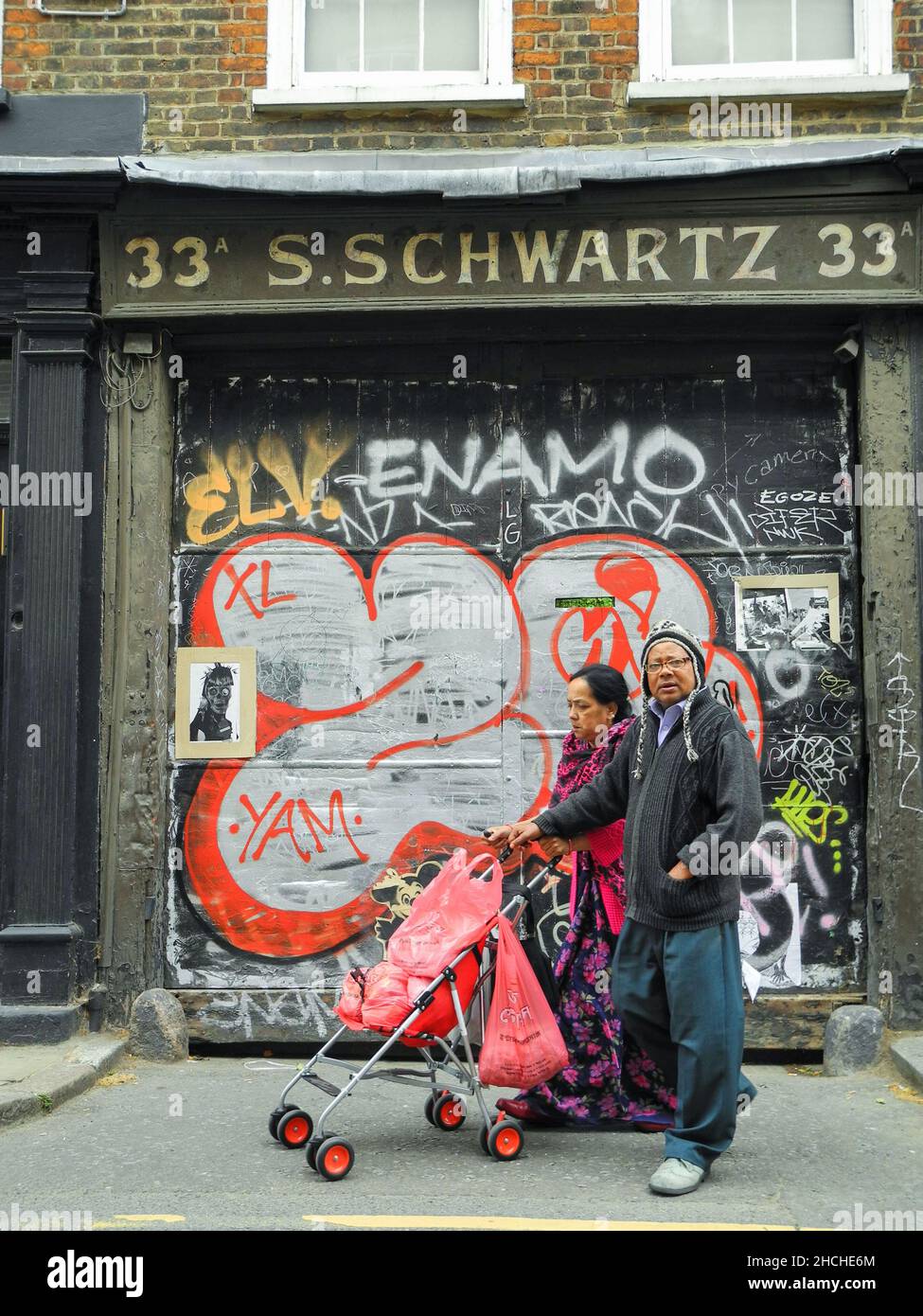 An elderly Indian man and his wife pushing a buggy loaded with food ...