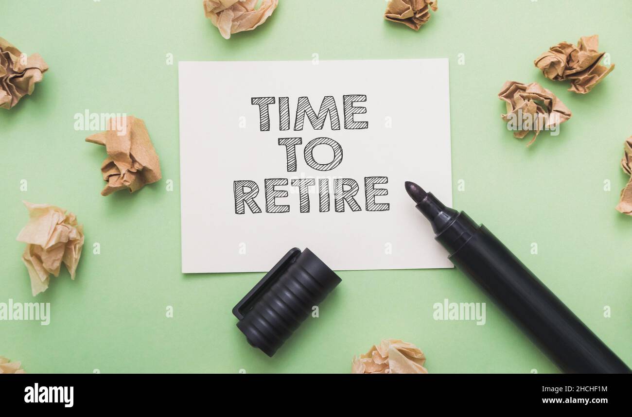 marker write time to retire on a white sticker with crumpled pieces of ...