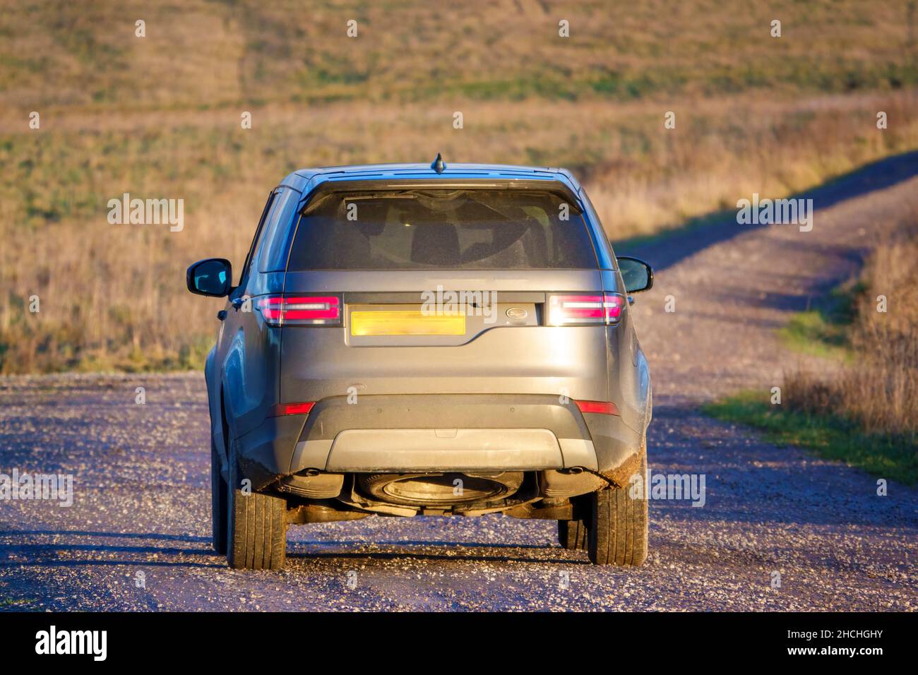 a Land Rover Discovery 5 driving along an unmade stone track road Stock ...