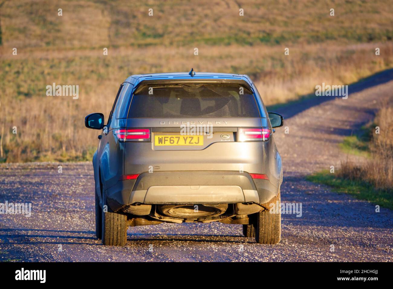 a Land Rover Discovery 5 driving along an unmade stone track road Stock ...