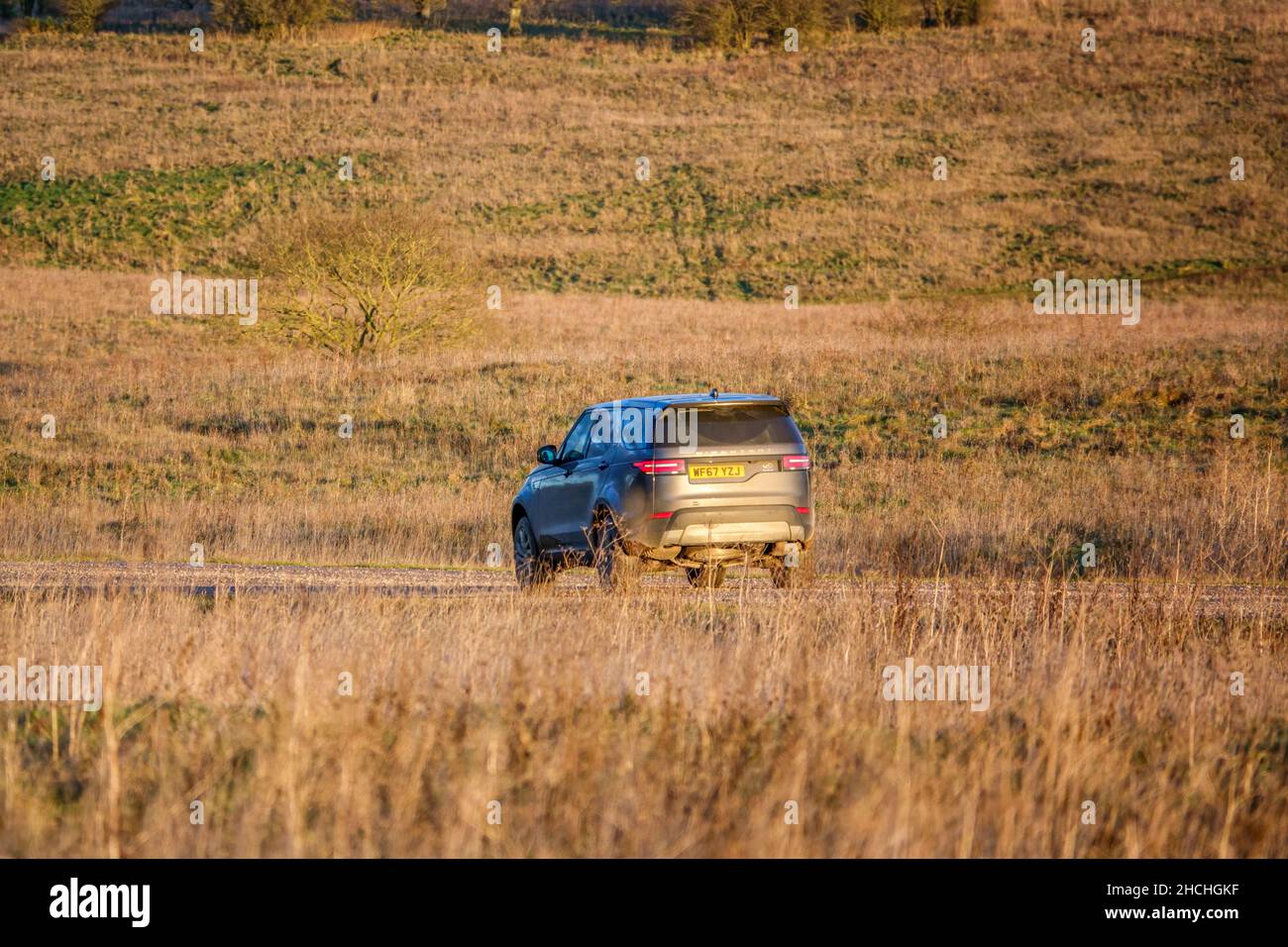 a Land Rover Discovery 5 driving along an unmade stone track road Stock ...