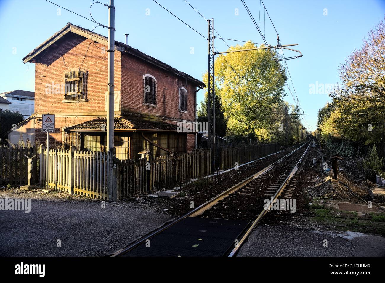 Old brick building by the edge of a railroad crossing at sunset Stock ...