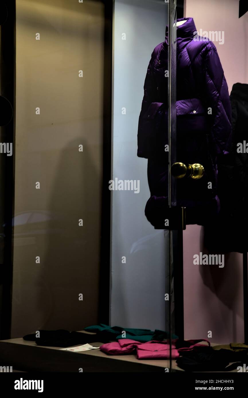 Purple coat in a shop window at night Stock Photo - Alamy