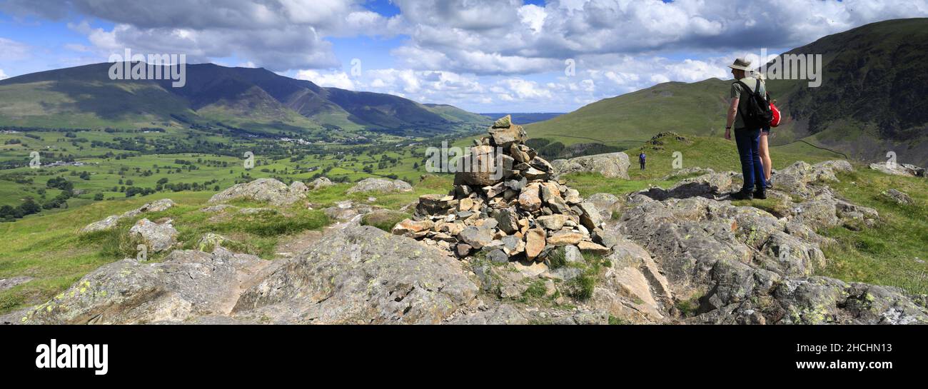 Walker at the summit cairn of High Rigg fell overlooking St Johns in ...