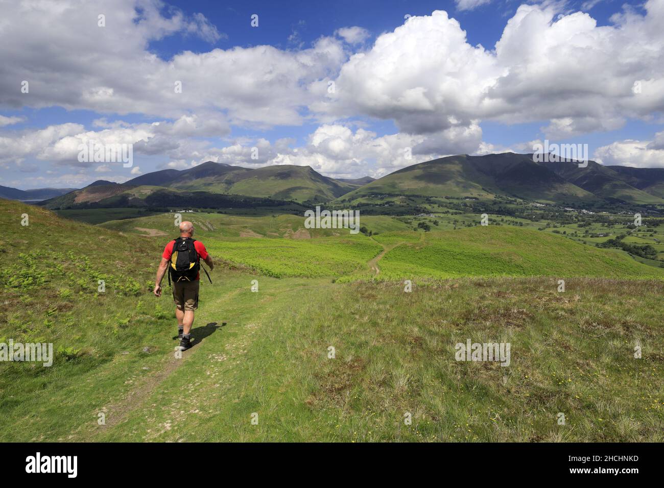 Walker at the summit cairn of High Rigg fell overlooking St Johns in ...