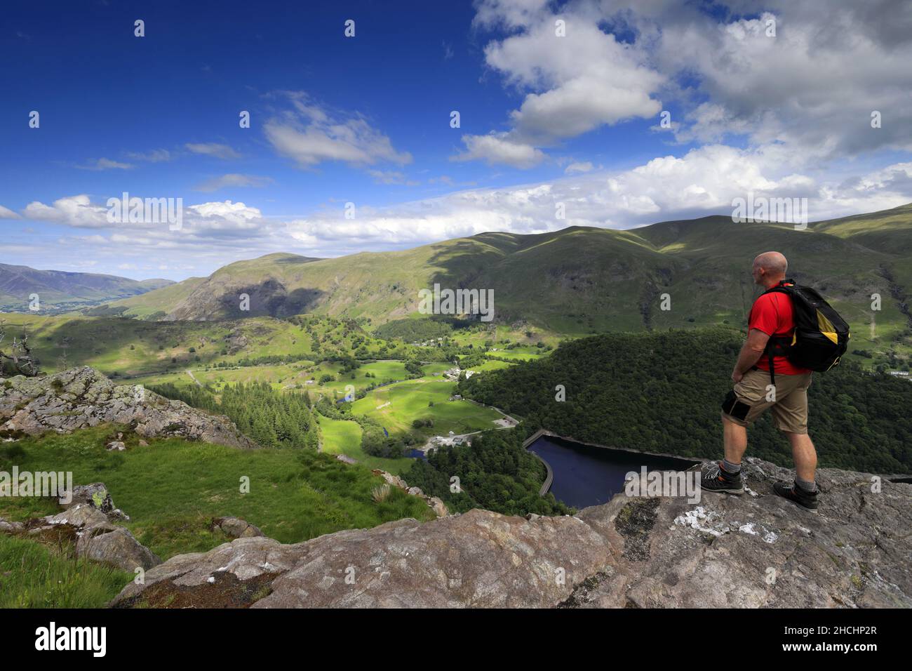 Walker at the summit cairn of Raven Crag fell overlooking Thirlmere ...