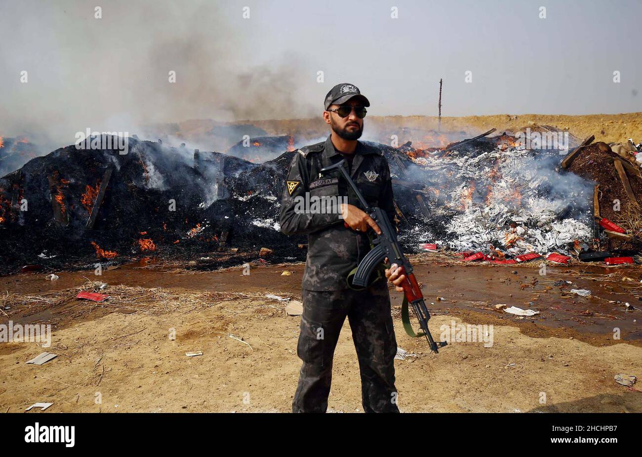 View of destroying liquor bottles and burning pile of confiscated drugs ...
