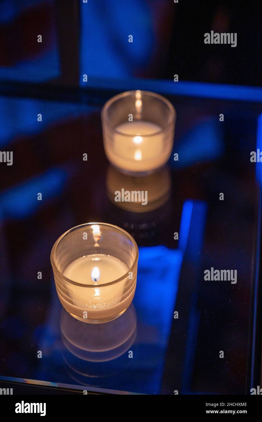 Shallow focus of candles with blue lights background Stock Photo - Alamy
