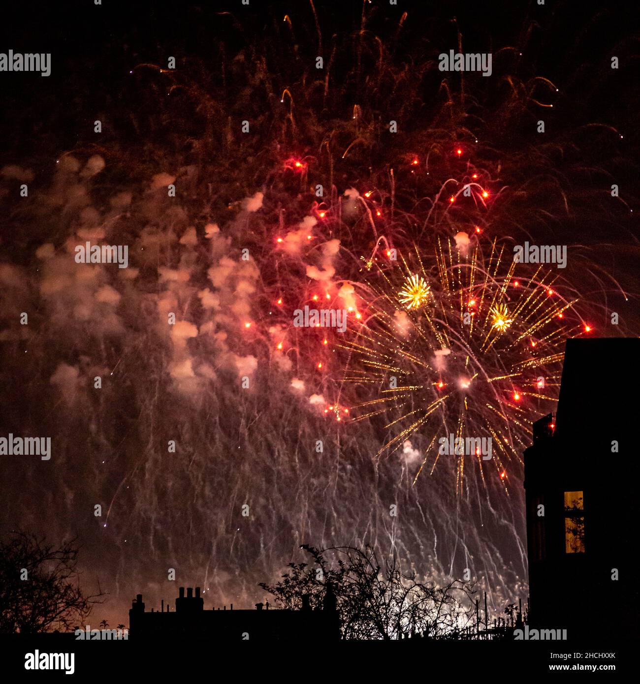 Building silhouetted against a night sky with fireworks exploding ...
