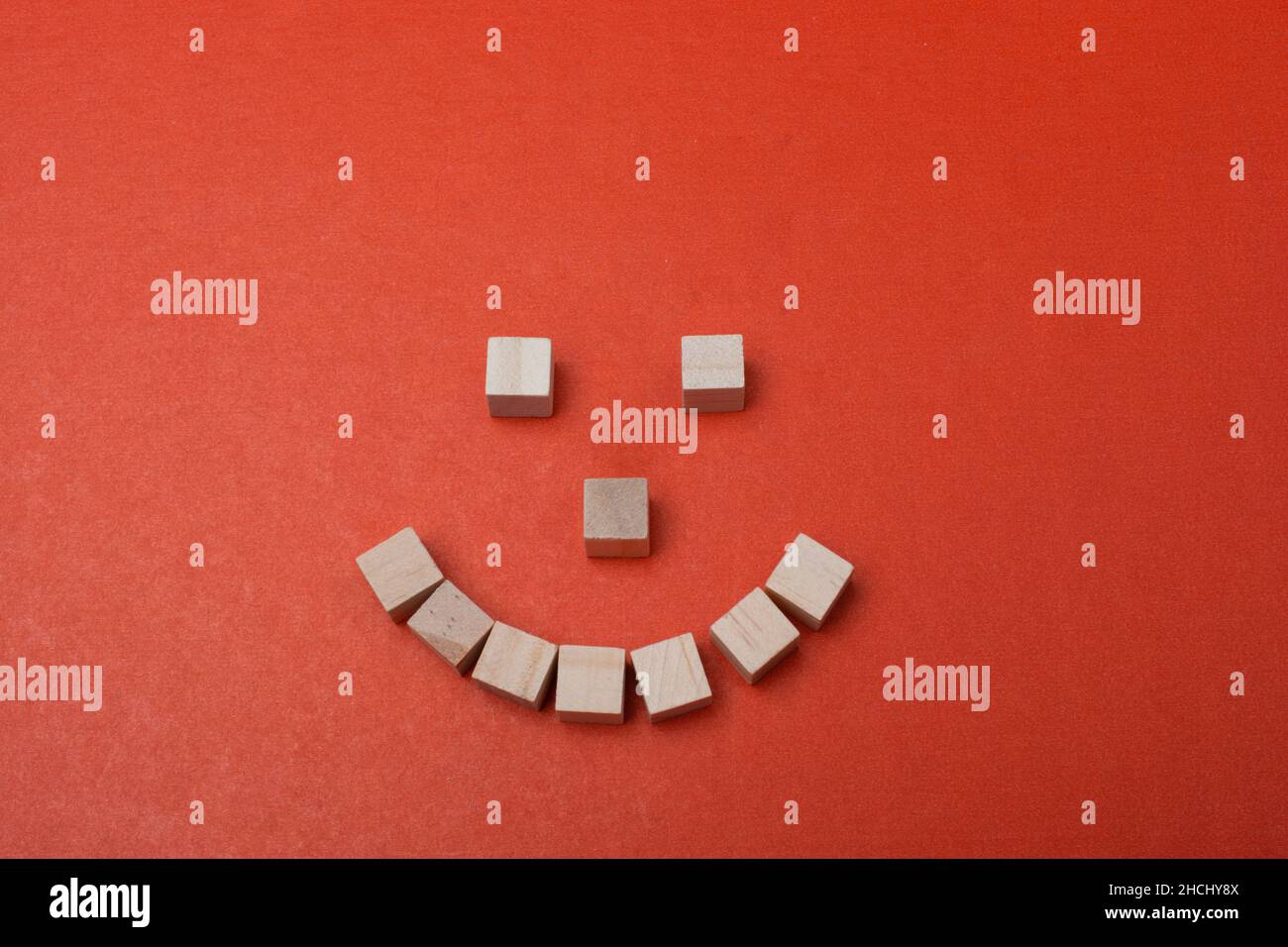 Smile of wooden cubes isolated on a red surface Stock Photo - Alamy