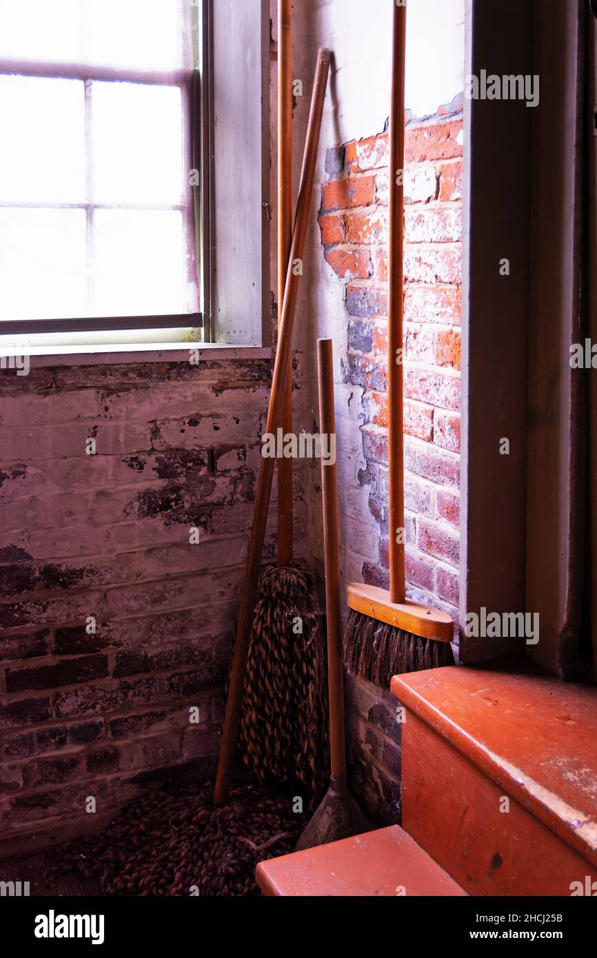 Mops and a broom hand from the wall in a corner of the laundry ...