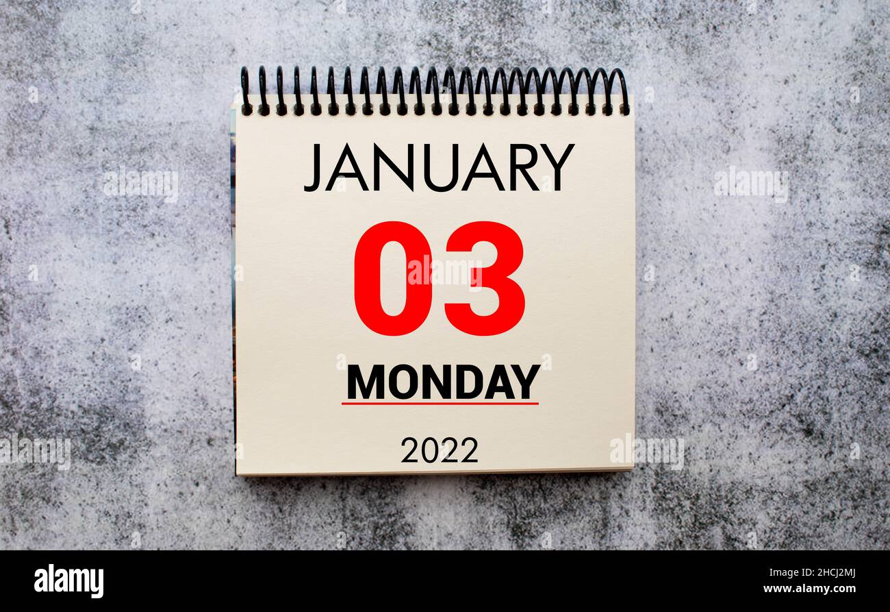 January 3 on a white Notepad.Nearby fir branches, red berries and cones ...