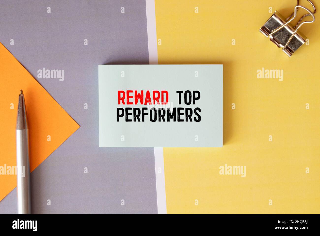 Reward top performers text memo written on a white background with ...