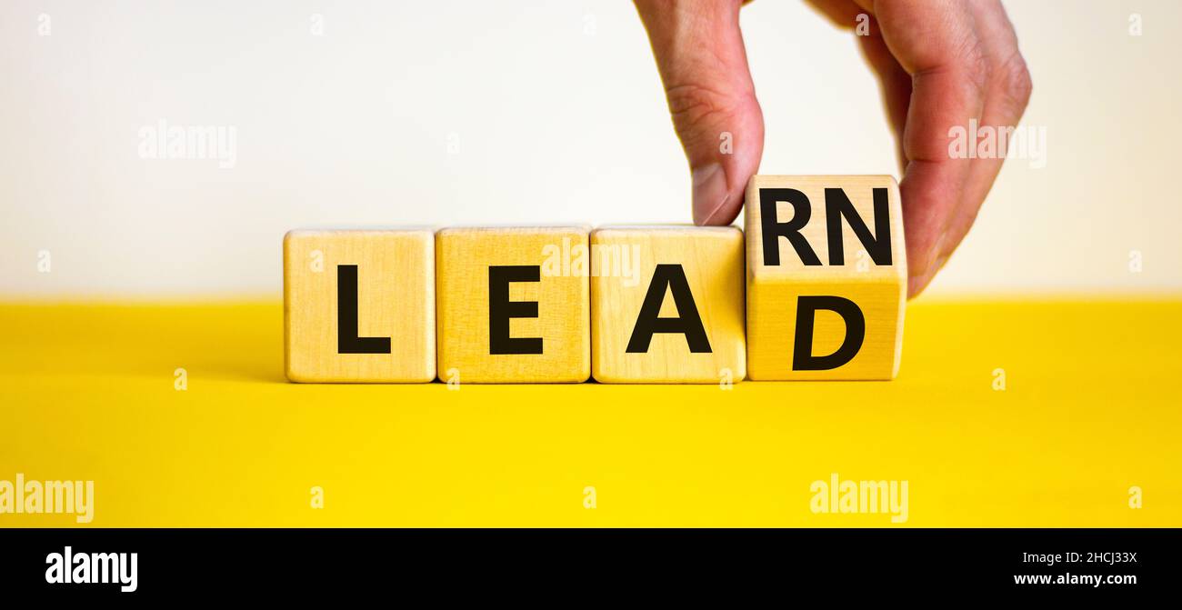 Learn and lead symbol. Businessman turns a wooden cube and changes the ...