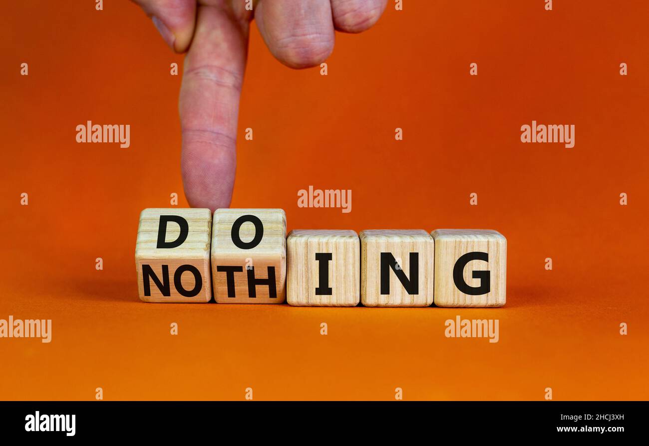 Doing or nothing symbol. Businessman turns wooden cubes and changes the ...